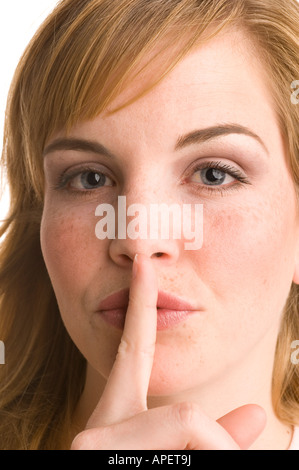 Hushing blond woman Stock Photo - Alamy