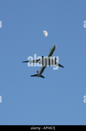 a jet plane flying past the moon at sunset Stock Photo - Alamy