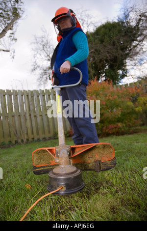 Person wearing orange coloured helmet black ear protectors and visor ...