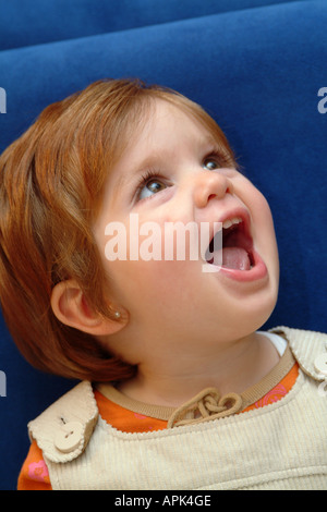 Close-up portrait of happy baby boy wearing cap while sitting on chair ...