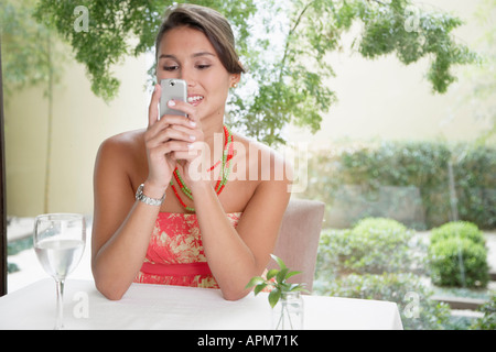 Woman reading text message at dining table Stock Photo - Alamy