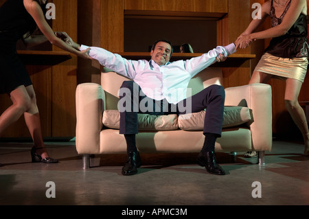 Man being pulled from both sides by women in a bar Stock Photo - Alamy