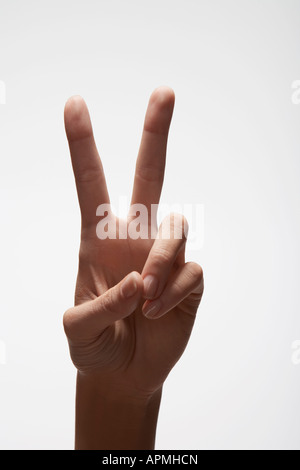 Woman's Hand Making Peace Sign With Long, White Nails Against Grey ...