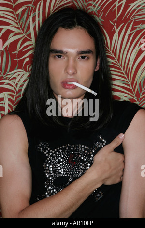 Young punk couple smoking a cigarette and drinking beer in a park. Rock ...