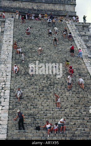 Tourists climbing the steep stairs of El Castillo Pyramid at Chichen ...