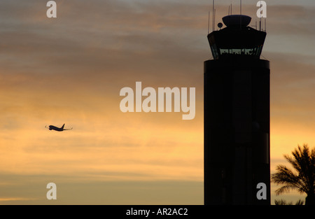 Airliner taking off past Control tower at Sunset Stock Photo - Alamy