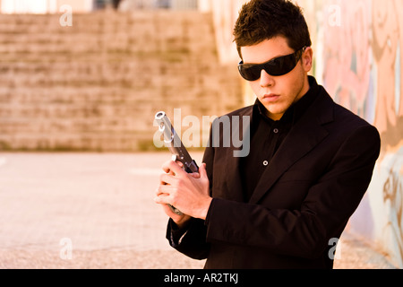 Male model performing secret agent with gun Stock Photo - Alamy