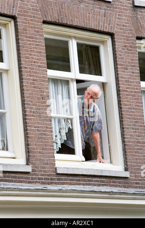 Man leaning out of first floor window of house painting wooden window ...