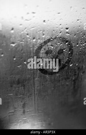 Sad face drawn on the condensation on a rainy window Stock Photo - Alamy