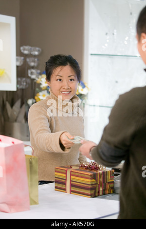 Smiling shop assistant wrapping gift box Stock Photo - Alamy