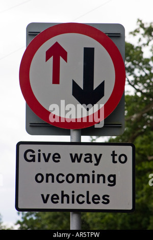 beware oncoming vehicles in middle of road road sign Stock Photo - Alamy