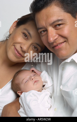 Proud happy hispanic parents posing with little cute girl wearing pink ...