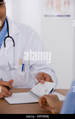Doctors lab coat and stethoscope handing on a wall isolated on white ...