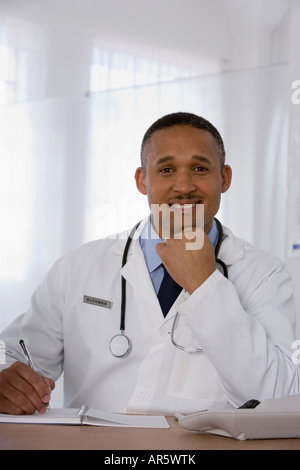 African doctor writing in notebook Stock Photo - Alamy