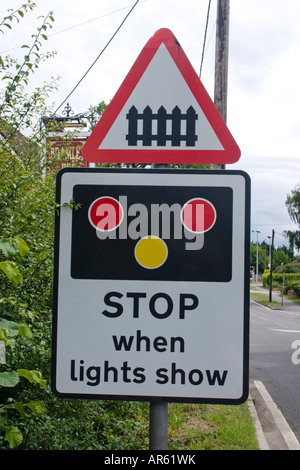 Level crossing with barrier or gate ahead road sign on white Stock ...