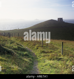 Doyden Castle on headland and house overlook the sea at sunset at Port ...