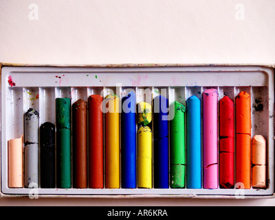 Heavily used colorful oil pastels in a cardboard and plastic case ...