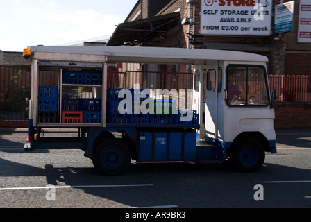 Milkman and electric powered vehicle delivering milk from house to ...