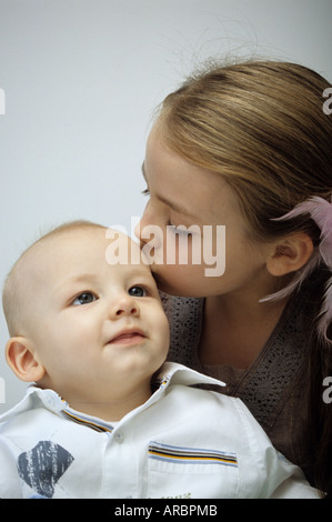 Siblings love care and affection. Older brother kissing little sister ...