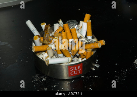 Full ashtray in a bar Stock Photo - Alamy