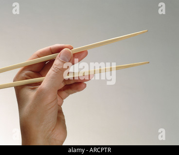 Side view of a male hand holding a freshly dug potato plant with ...