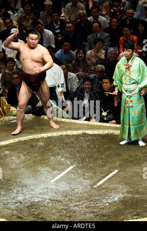 A sumo wrestler throws salt to purify the ring before his bout at the ...