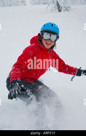 Idaho. A happy snowboarder enjoys a fresh powder day in the mountains ...