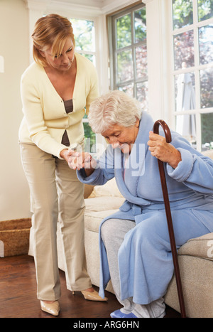 Elderly woman with an aid for standing up, nursing home, rehabilitation ...