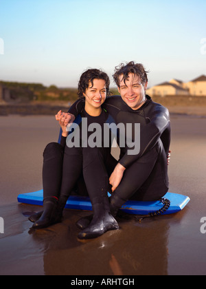 Couple in wetsuits Stock Photo - Alamy