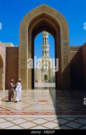 A vertical shot of an arch building with a man passing by during a ...