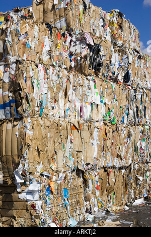 Bales of waste paper and cardboard cartons stacked awaiting recycling ...