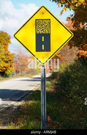 Traffic sign alerting motorist drivers that paved highway turns into a ...