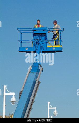 Window washers use mechanical industrial boom to elevate them against ...