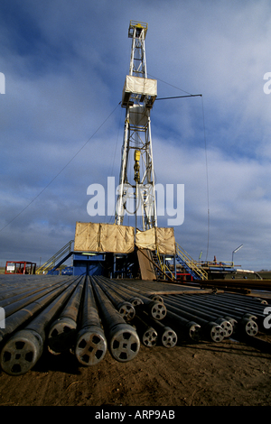 Drilling pipe sections lay on ground near oil well drill rig Snyder ...