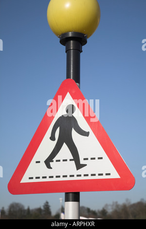 Triangle red and yellow road sign stands on the roadside. Men at Stock ...