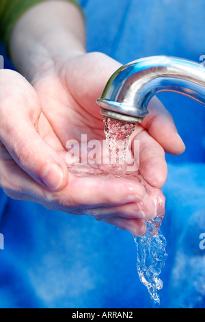 Mineral water falling to hands Stock Photo - Alamy