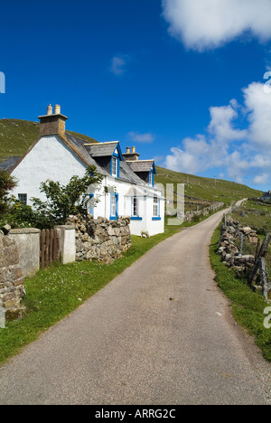 White Scottish Highland croft cottage with blue door and grazing sheep ...