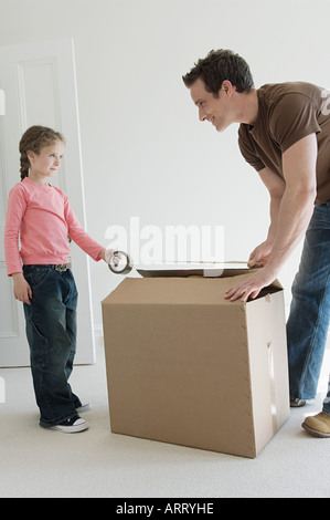 Smiling man taping moving box Stock Photo - Alamy