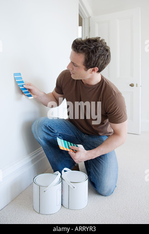 Man holding tin of white paint and roller Stock Photo - Alamy