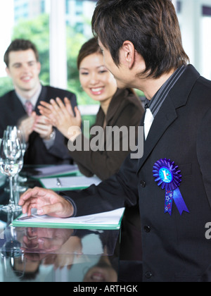 Chinese businesspeople clapping and congratulating team leader Stock ...