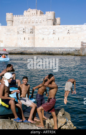 Egyptian boys swimming and diving off the rocks of the mediterranean ...