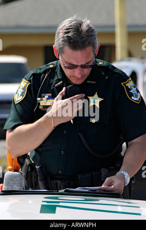 Male police officer using microphone to communicate on the scene of an ...