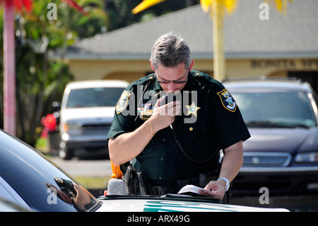 Male police officer using microphone to communicate on the scene of an ...