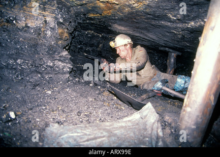 Miners down a mine shaft sitting eating drinking and Smoking in the ...