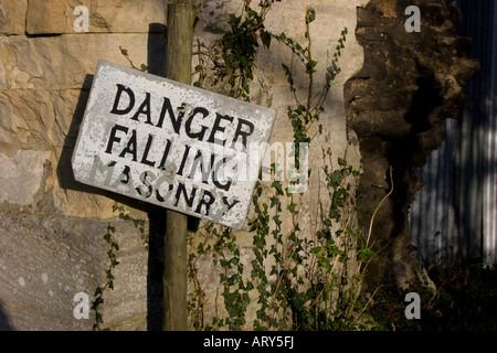 Lop-sided sign warning of: Danger, falling masonry Stock Photo - Alamy