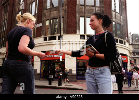 Young woman handing out leaflets on the street at rush hour Stock Photo ...