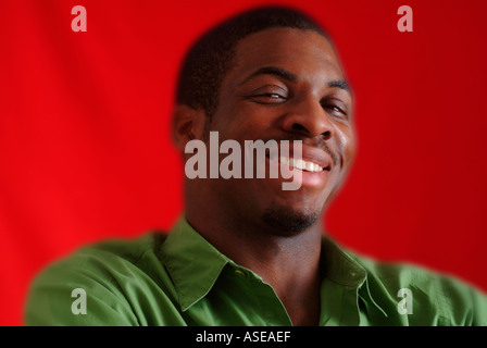 Happy young African man smiling against brown background Stock Photo ...
