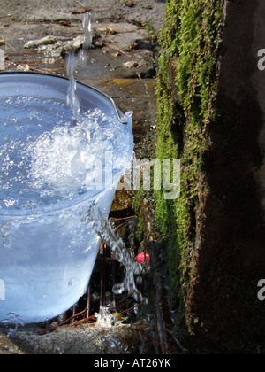 Water fountain with a bucket, detail of a water container grab Stock ...