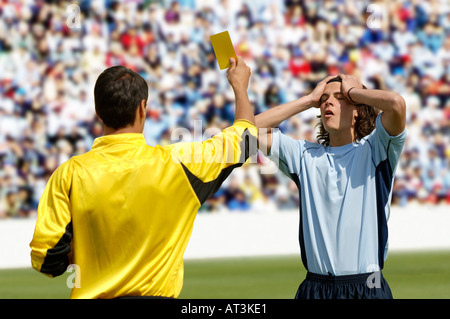 Referee showing yellow card to disappointed player Stock Photo - Alamy