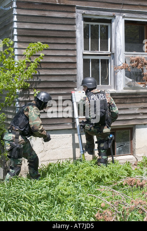 SWAT team members moving towards house to break window and deploy a ...